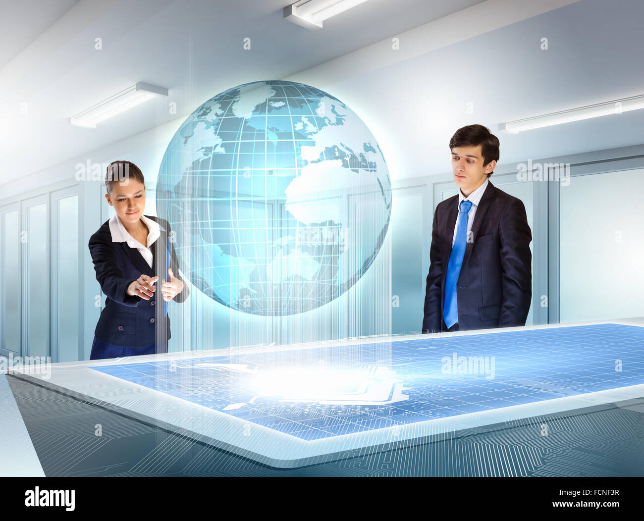 young businesspeople looking at high-tech image of globe Stock Photo ...