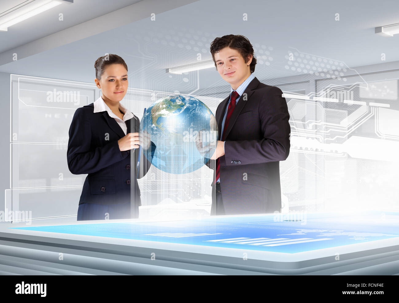 young businesspeople looking at high-tech image of globe Stock Photo ...