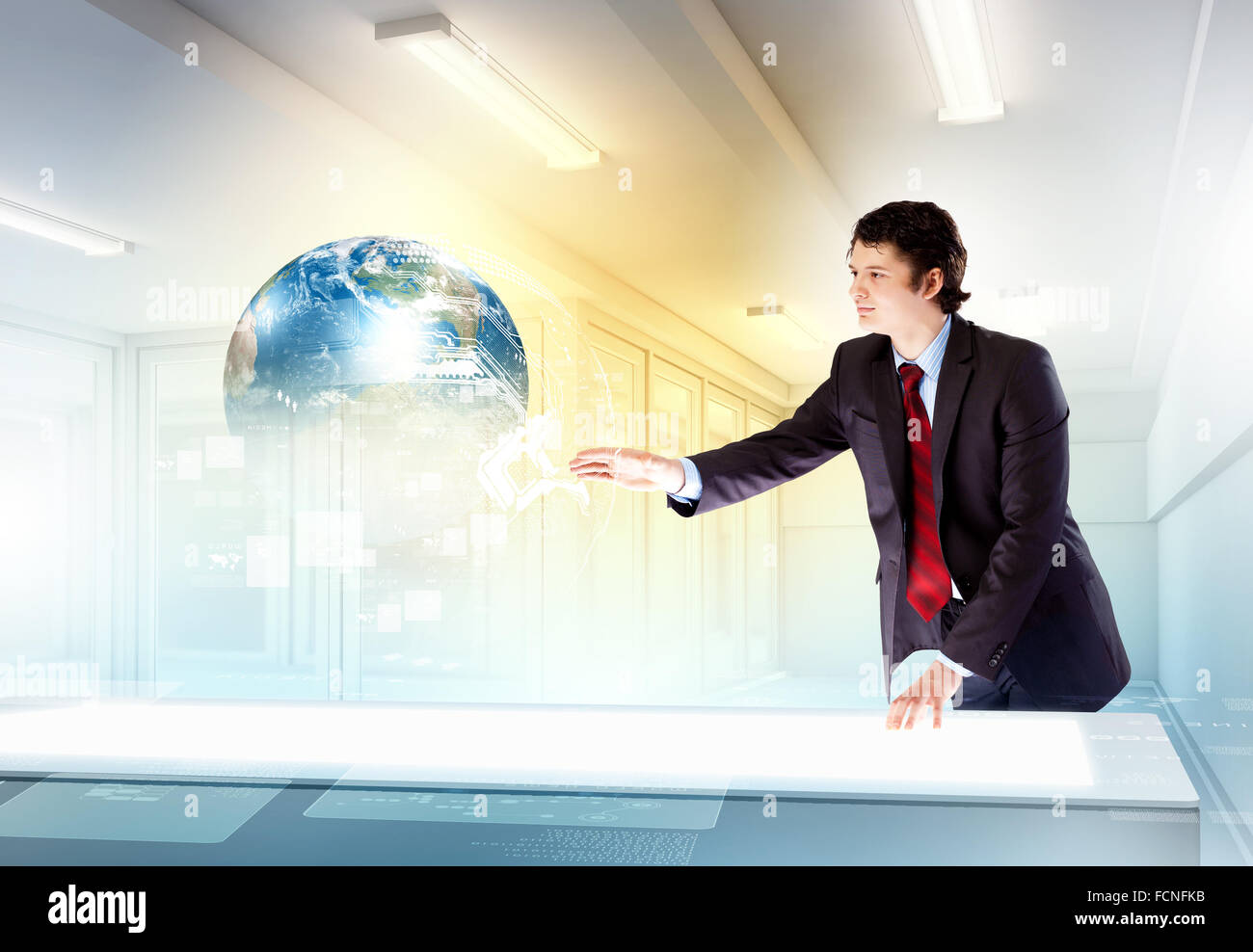 Image of young businessman clicking icon on high-tech picture of globe ...