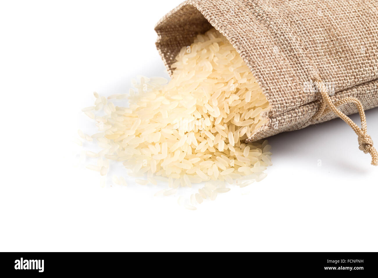 Rice in a sack and spilled on a white background Stock Photo - Alamy