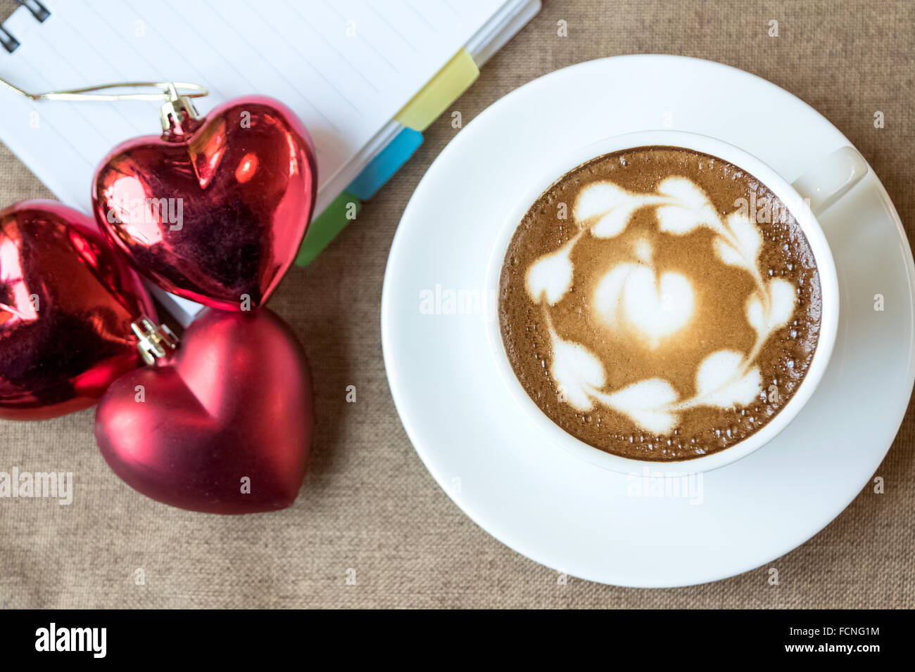 Hot coffee latte, latte art with red heart in white cup on a table ...