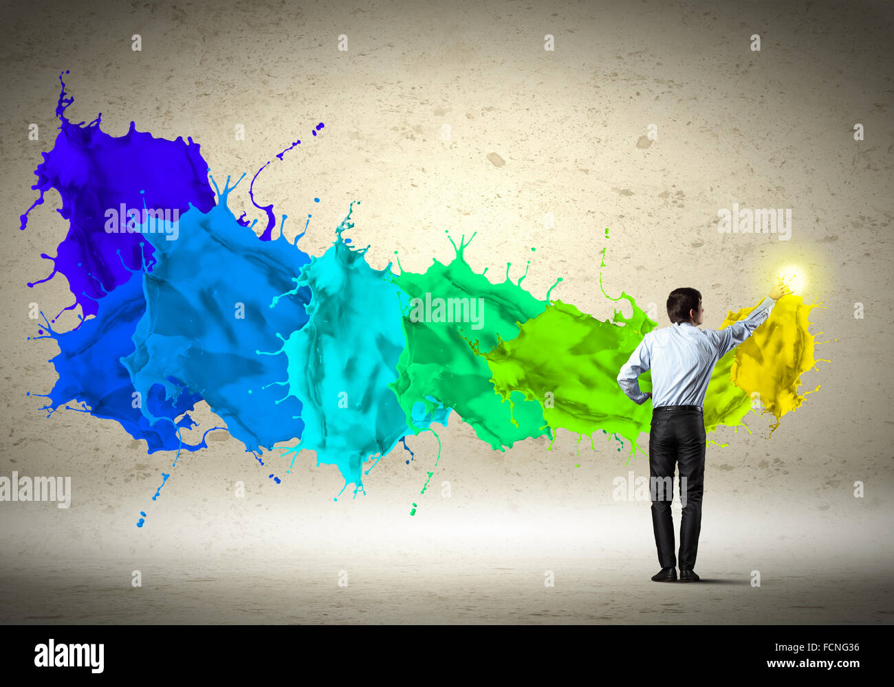 young man standing with back painting splashes with fingers Stock Photo ...