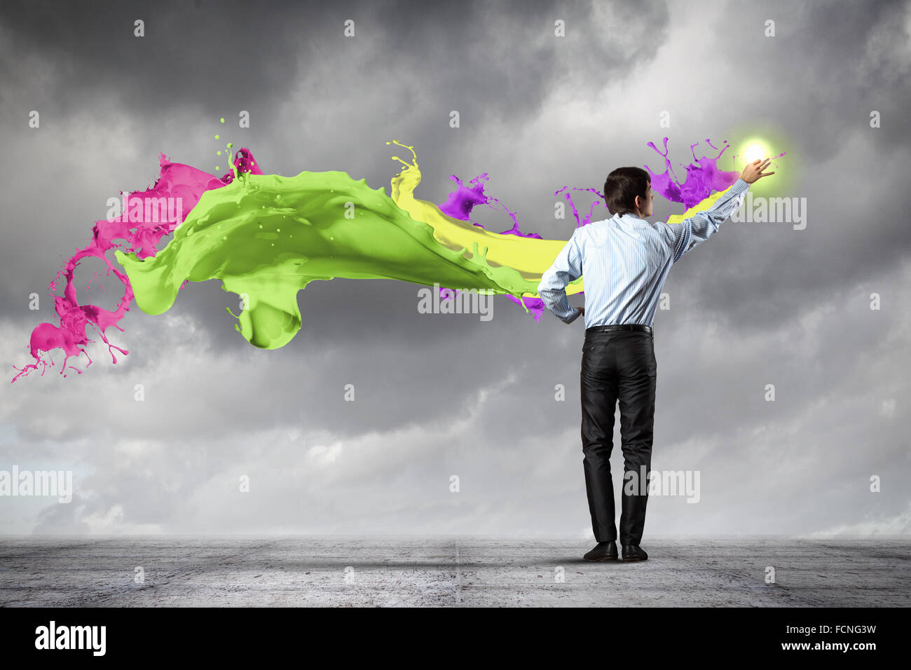 young man standing with back painting splashes with fingers Stock Photo ...
