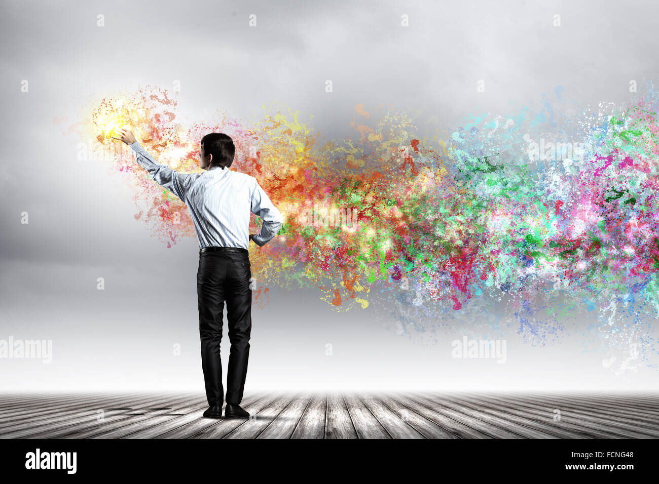 young man standing with back painting splashes with fingers Stock Photo ...