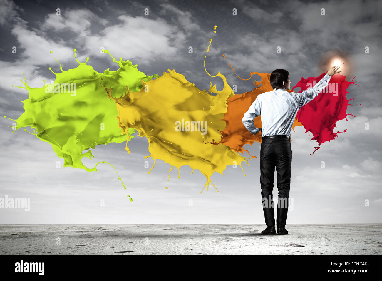 young man standing with back painting splashes with fingers Stock Photo ...