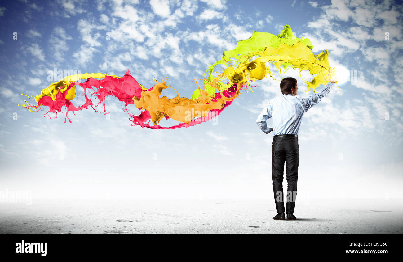 young man standing with back painting splashes with fingers Stock Photo ...