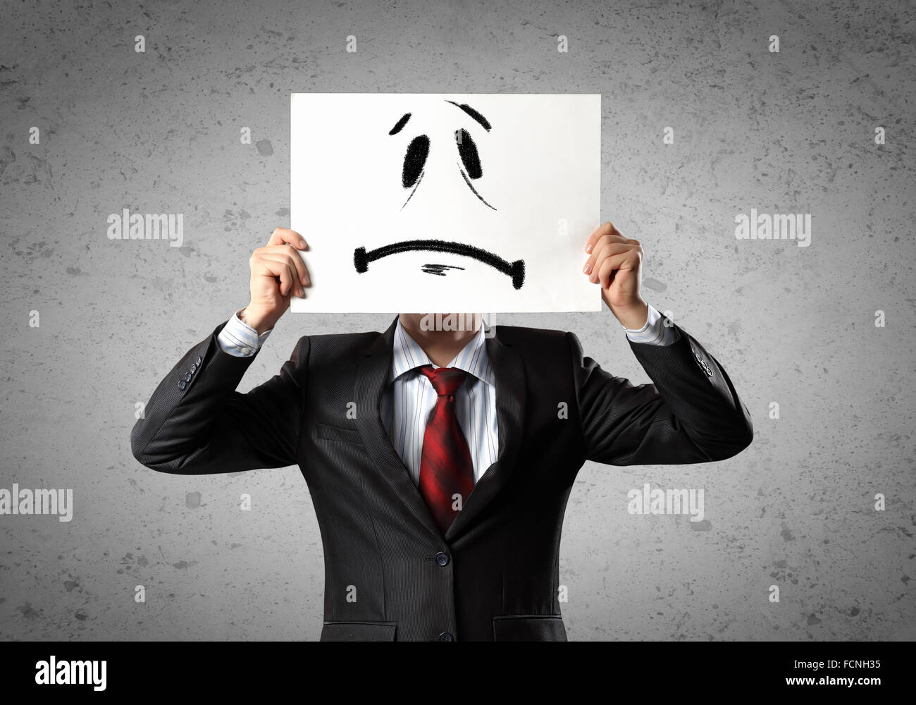 Image of businessman holding drawing of upset face. Conceptual photo ...