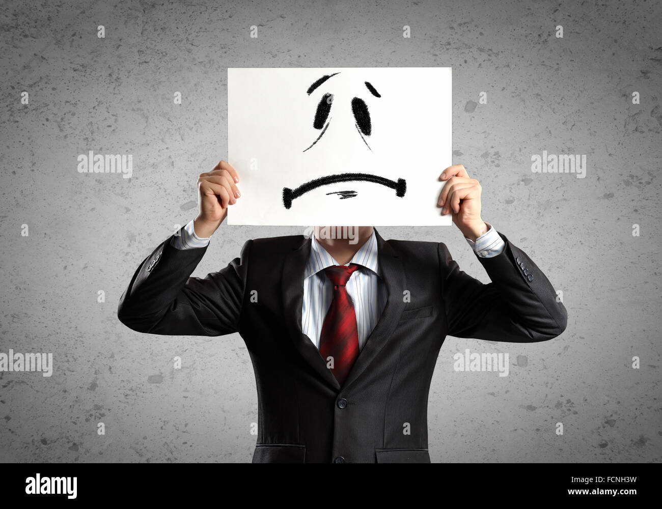 Image of businessman holding drawing of upset face. Conceptual photo ...