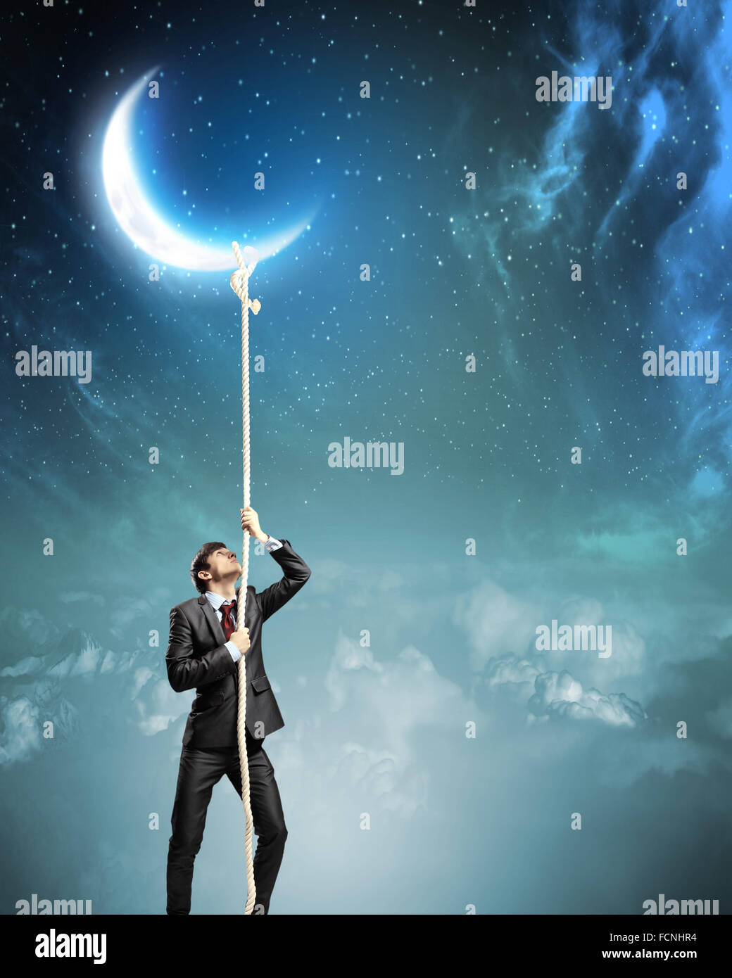 Image of businessman climbing rope attached to moon Stock Photo - Alamy