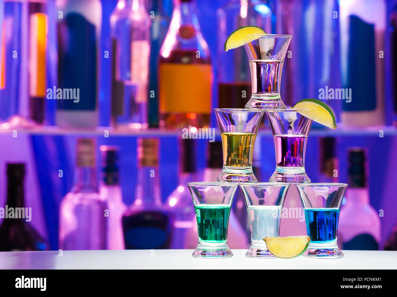 Pyramid of shot glasses with drinks and lime Stock Photo - Alamy