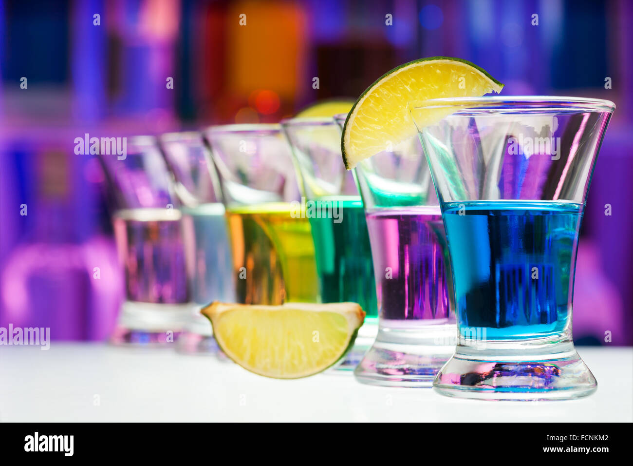 Long perspective row of shots with color drinks Stock Photo - Alamy