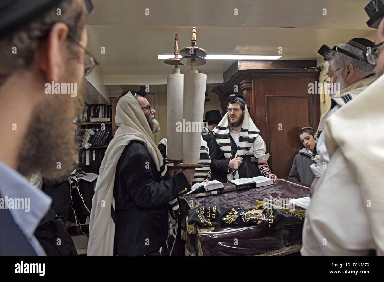 After a reading, a Torah scroll is raised and shown to the congregation ...