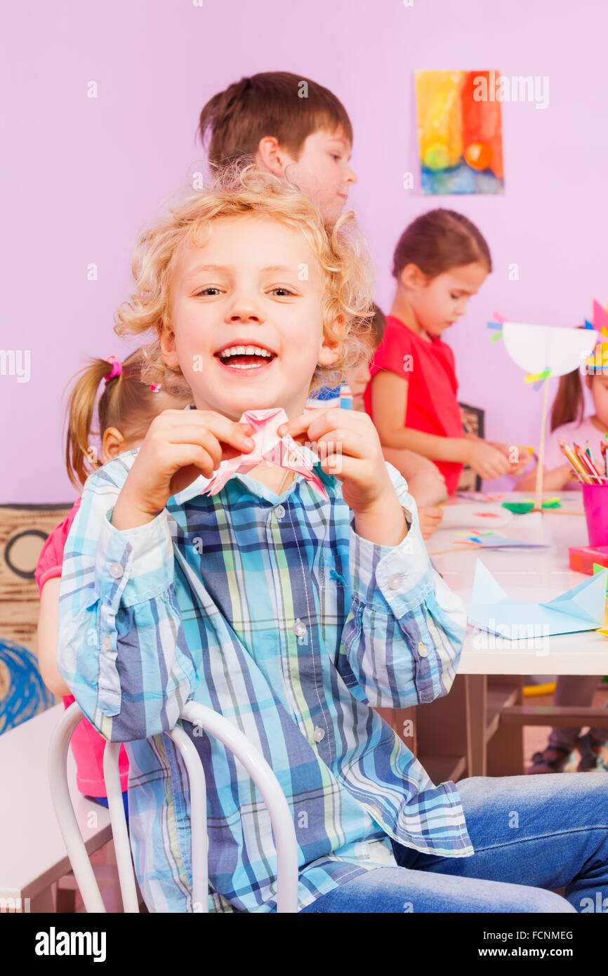 Happy little boy shows his craft made of paper Stock Photo - Alamy