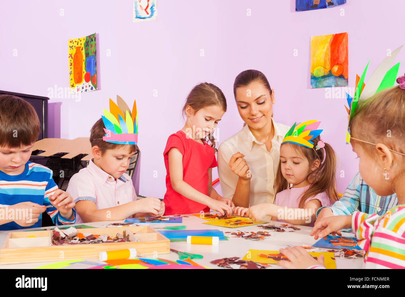 Teacher work with kids in art preschool class Stock Photo - Alamy