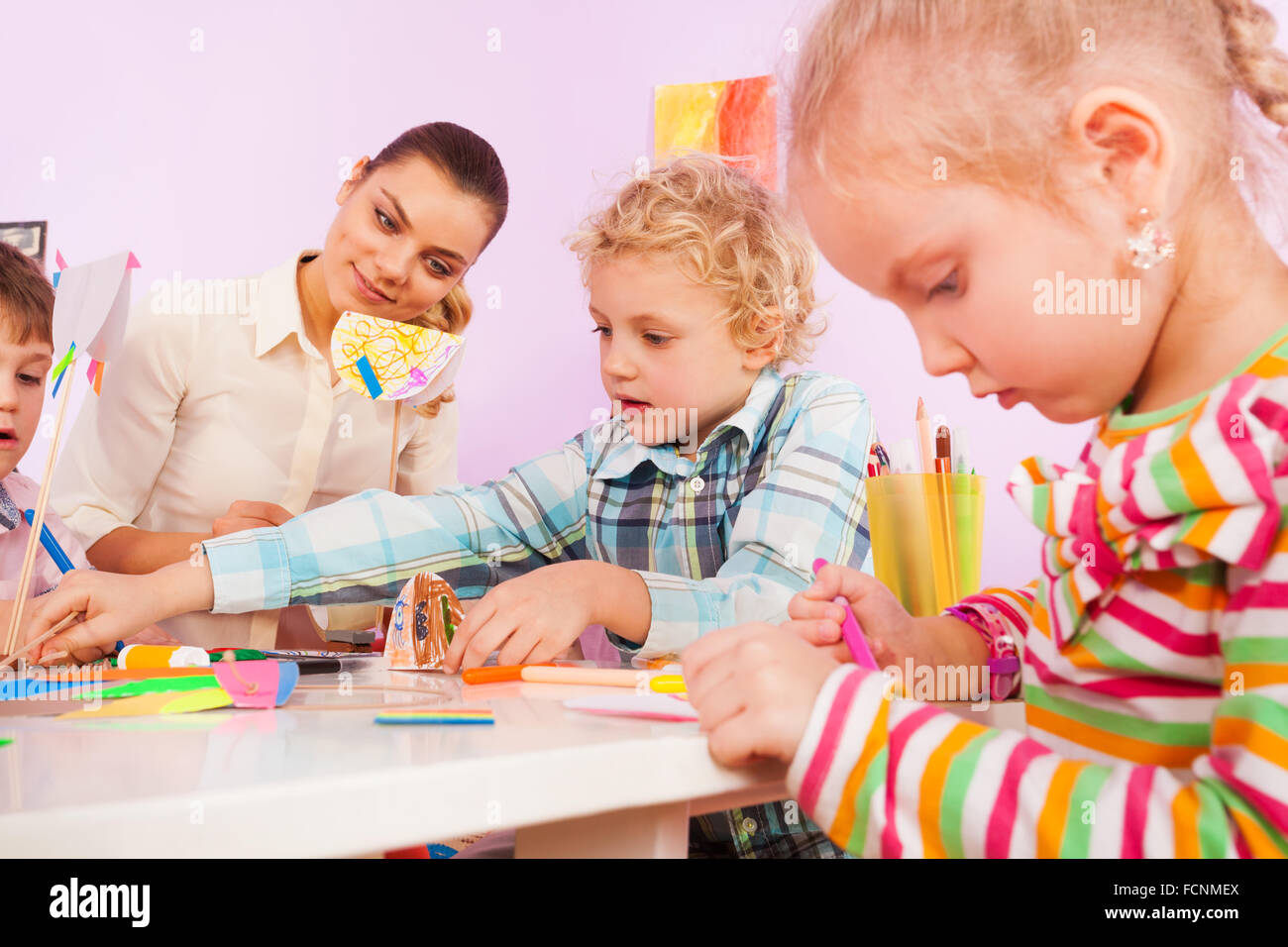 Teacher and little children crafting in class Stock Photo - Alamy