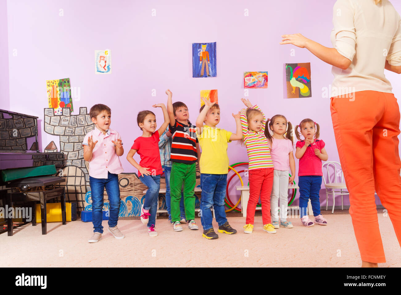 Group of kids repeating exercise after teacher Stock Photo - Alamy