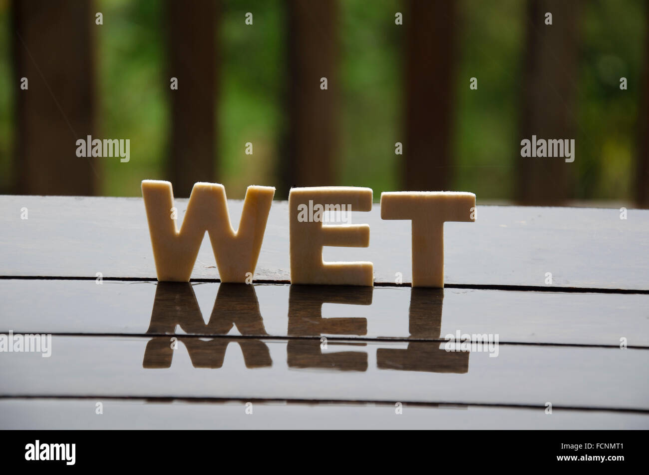 Letters forming the word "wet" laid on a table in the rain Stock Photo ...