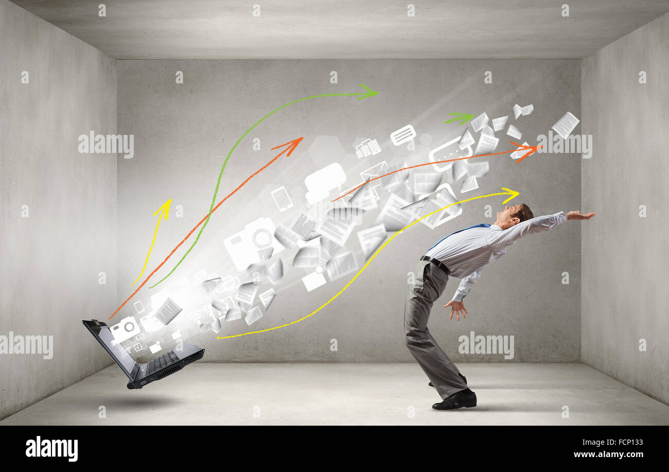 Young businessman evading icon flying from laptop Stock Photo - Alamy