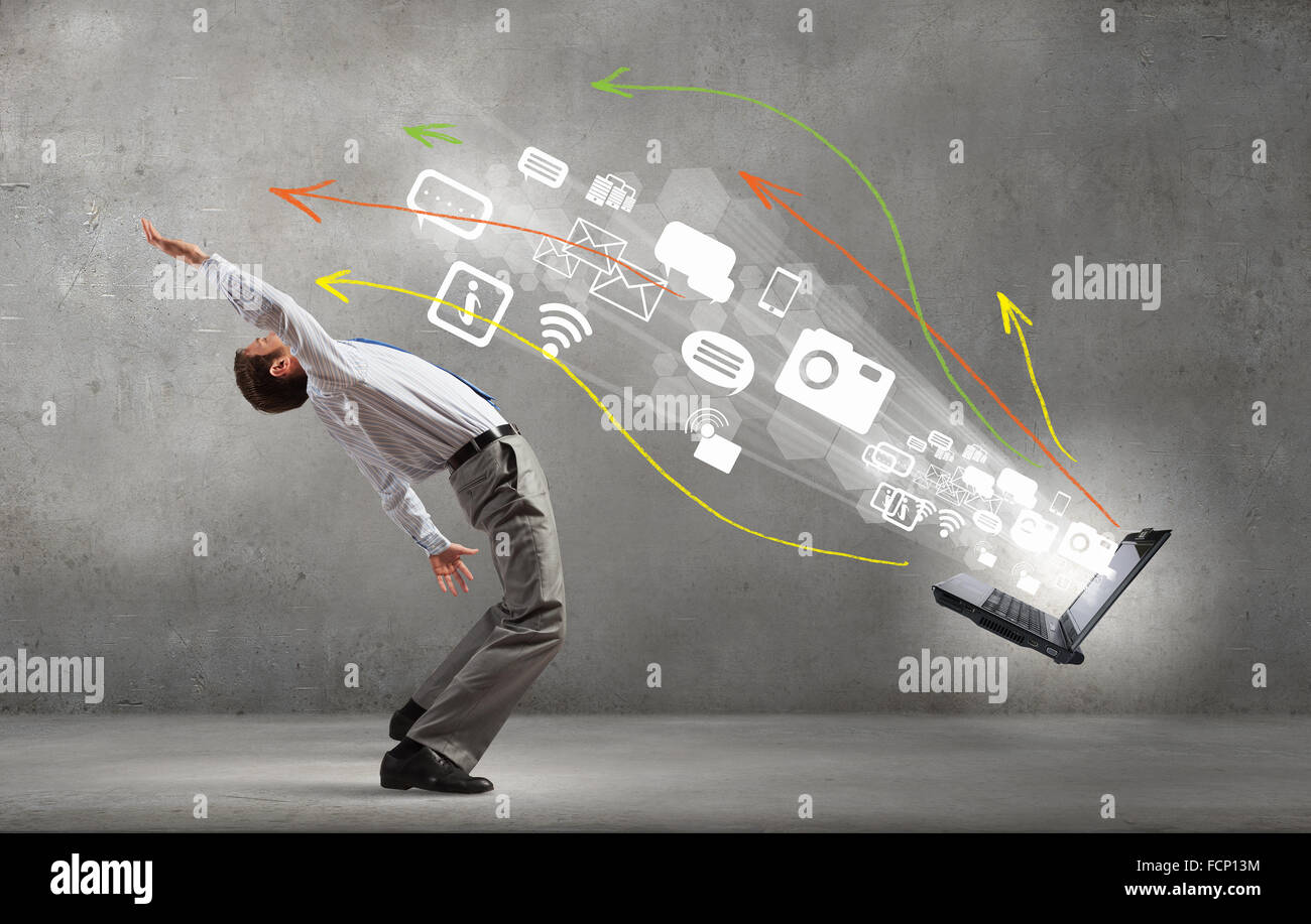 Young businessman evading icon flying from laptop Stock Photo - Alamy