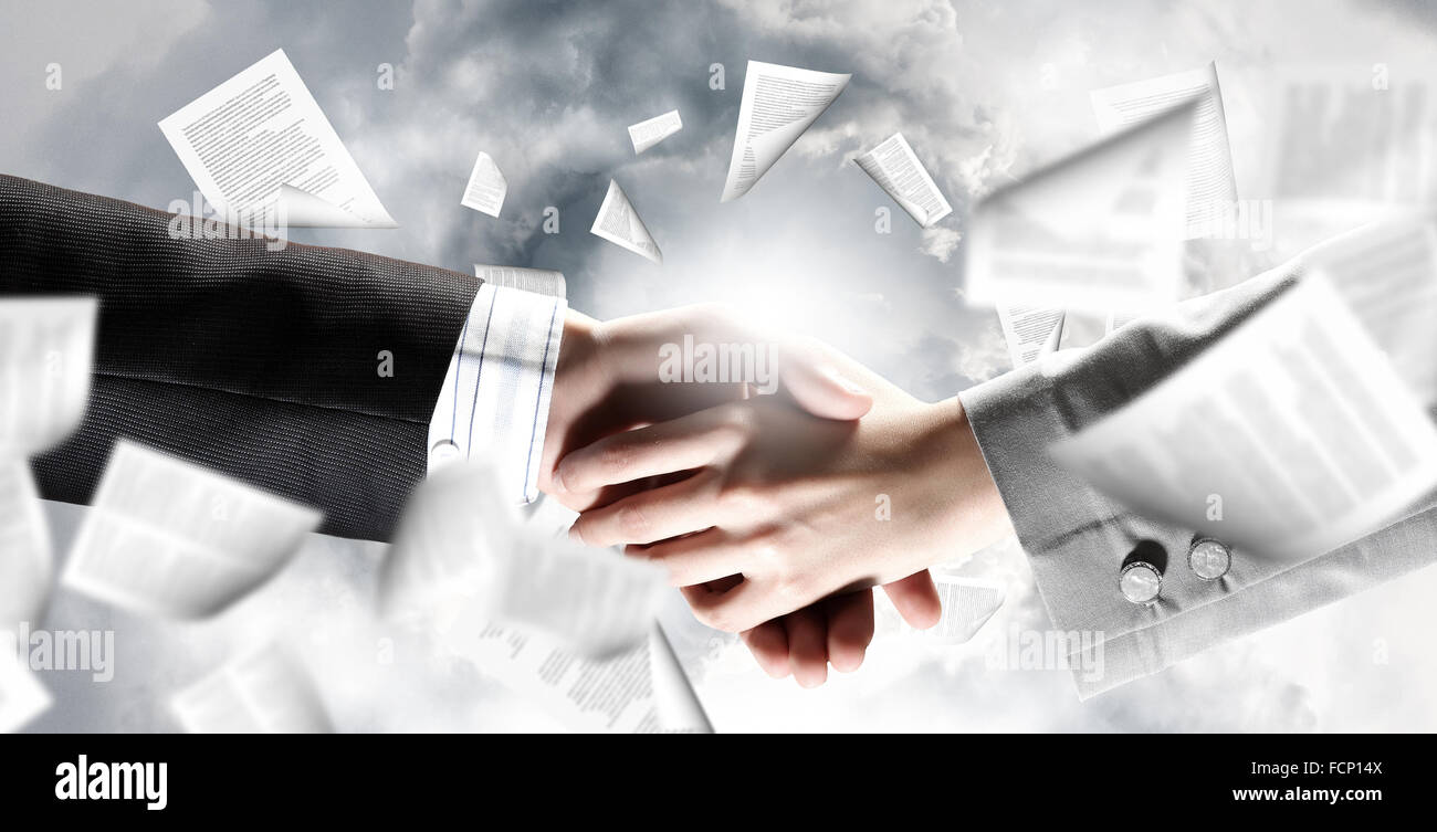 Close up of business handshake with papers at background Stock Photo ...