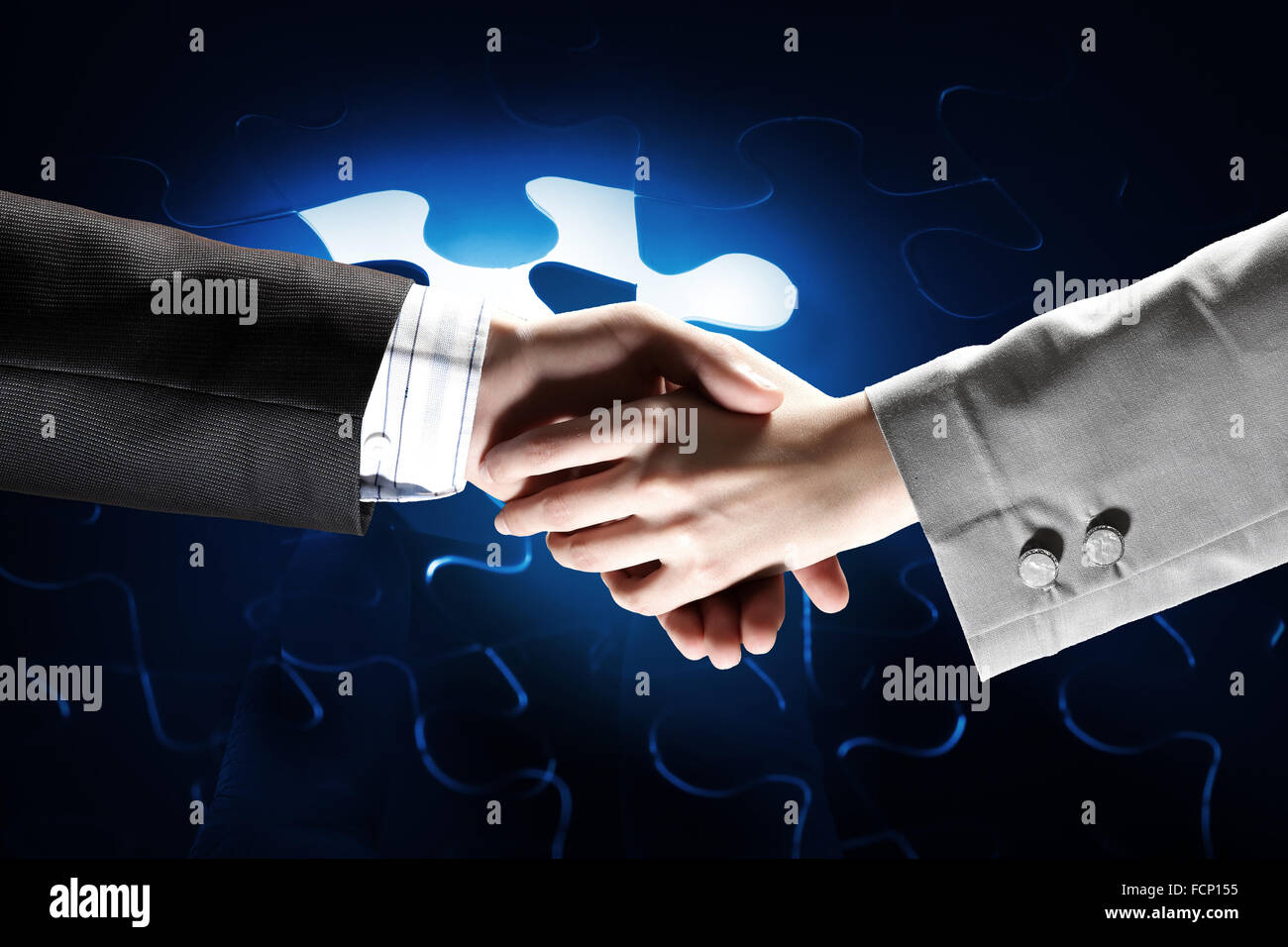 Close up of business handshake with puzzle elements at background Stock ...