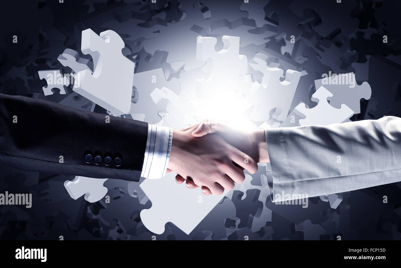 Close up of business handshake with puzzle elements at background Stock ...