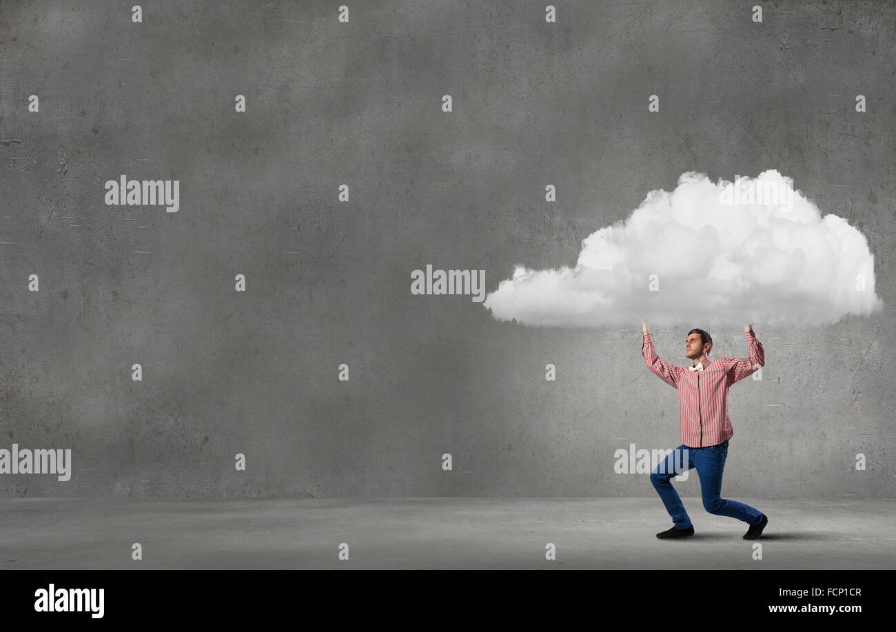 Young man in casual carrying cloud above head Stock Photo - Alamy