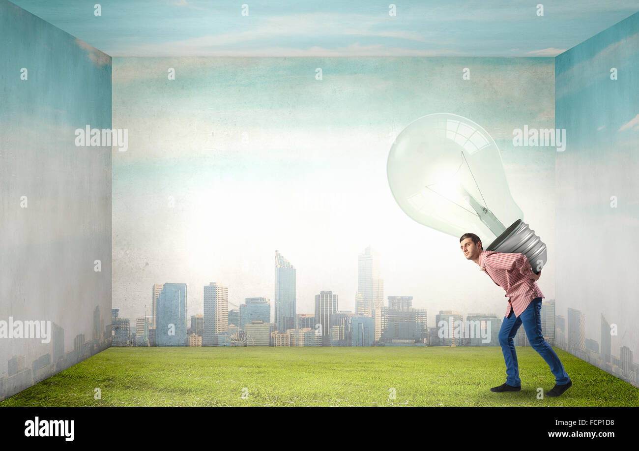 Young guy carrying light bulb on his back Stock Photo - Alamy