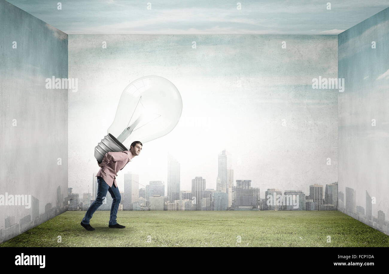 Young guy carrying light bulb on his back Stock Photo - Alamy