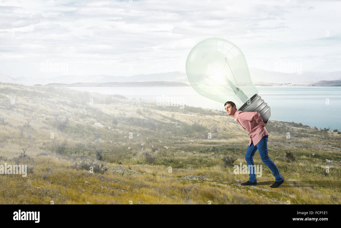 Young guy carrying light bulb on his back Stock Photo - Alamy