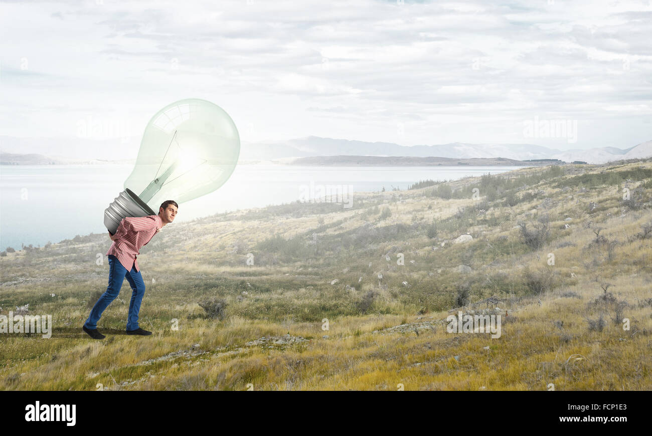 Young guy carrying light bulb on his back Stock Photo - Alamy