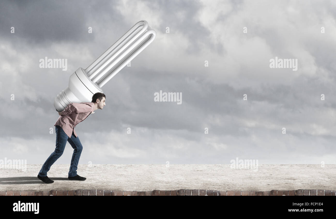 Young guy carrying light bulb on his back Stock Photo - Alamy
