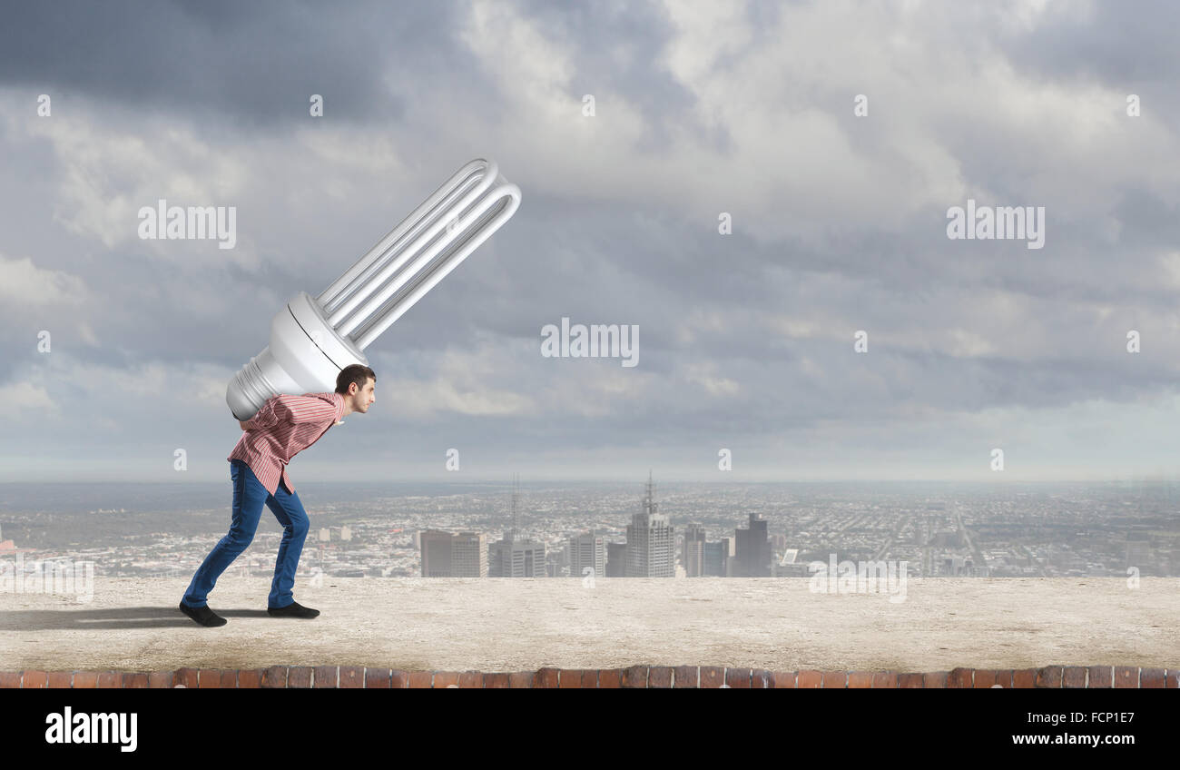 Young guy carrying light bulb on his back Stock Photo - Alamy