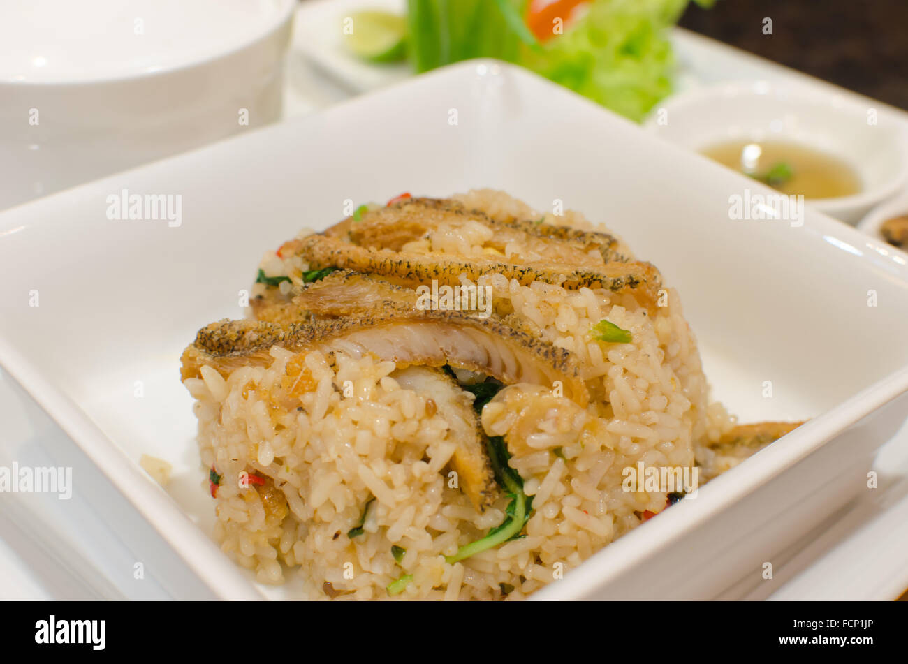 Fried rice with fried fish on dish Stock Photo - Alamy