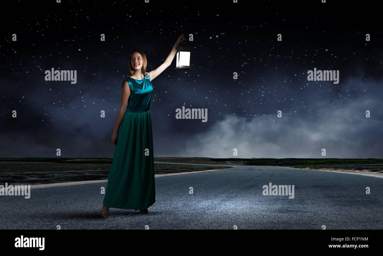 Young woman with lantern walking in darkness Stock Photo - Alamy