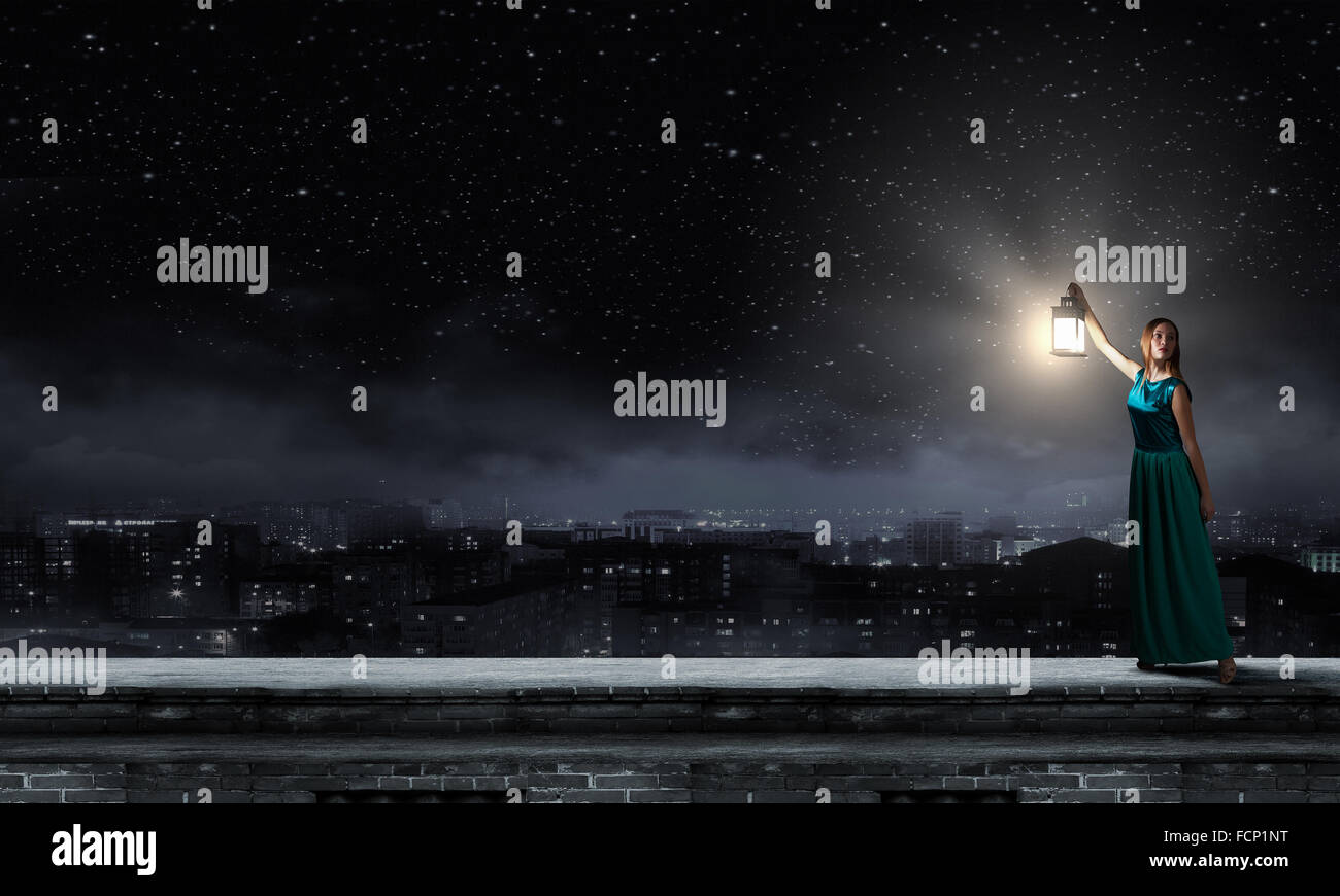 Young woman with lantern walking in darkness Stock Photo - Alamy