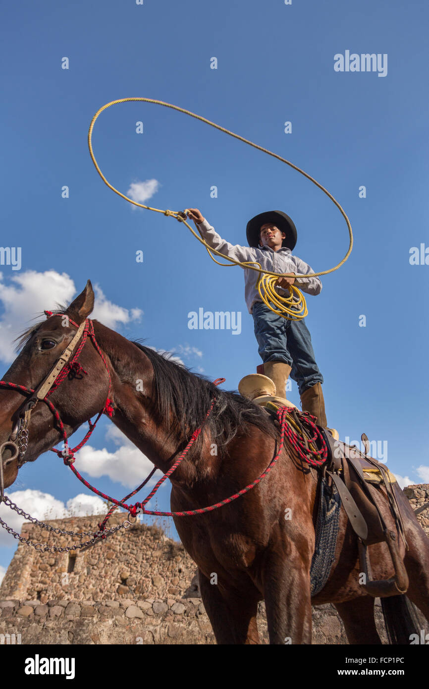 A Mexican charro or cowboy practices roping skills on his horse before ...