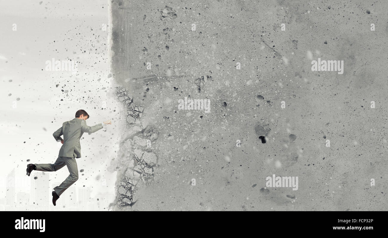 Businessman breaking stone wall with karate punch Stock Photo - Alamy