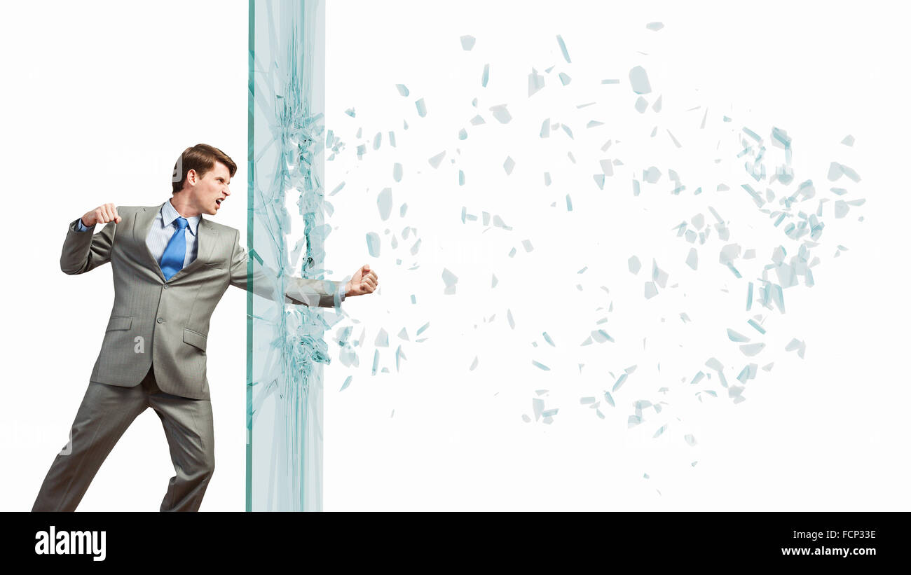 Young determined businessman breaking glass with karate punch Stock ...