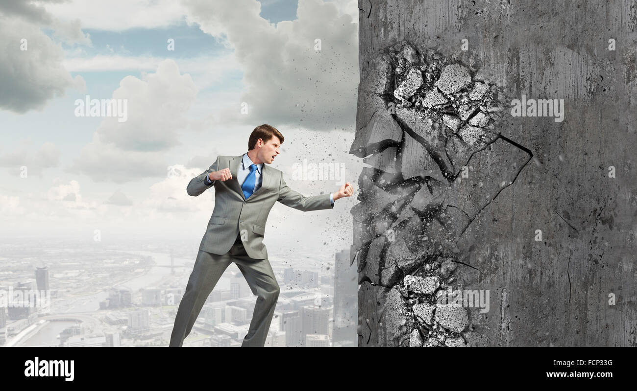 Businessman breaking stone wall with karate punch Stock Photo - Alamy