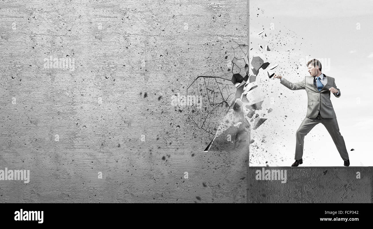 Businessman breaking stone wall with karate punch Stock Photo - Alamy