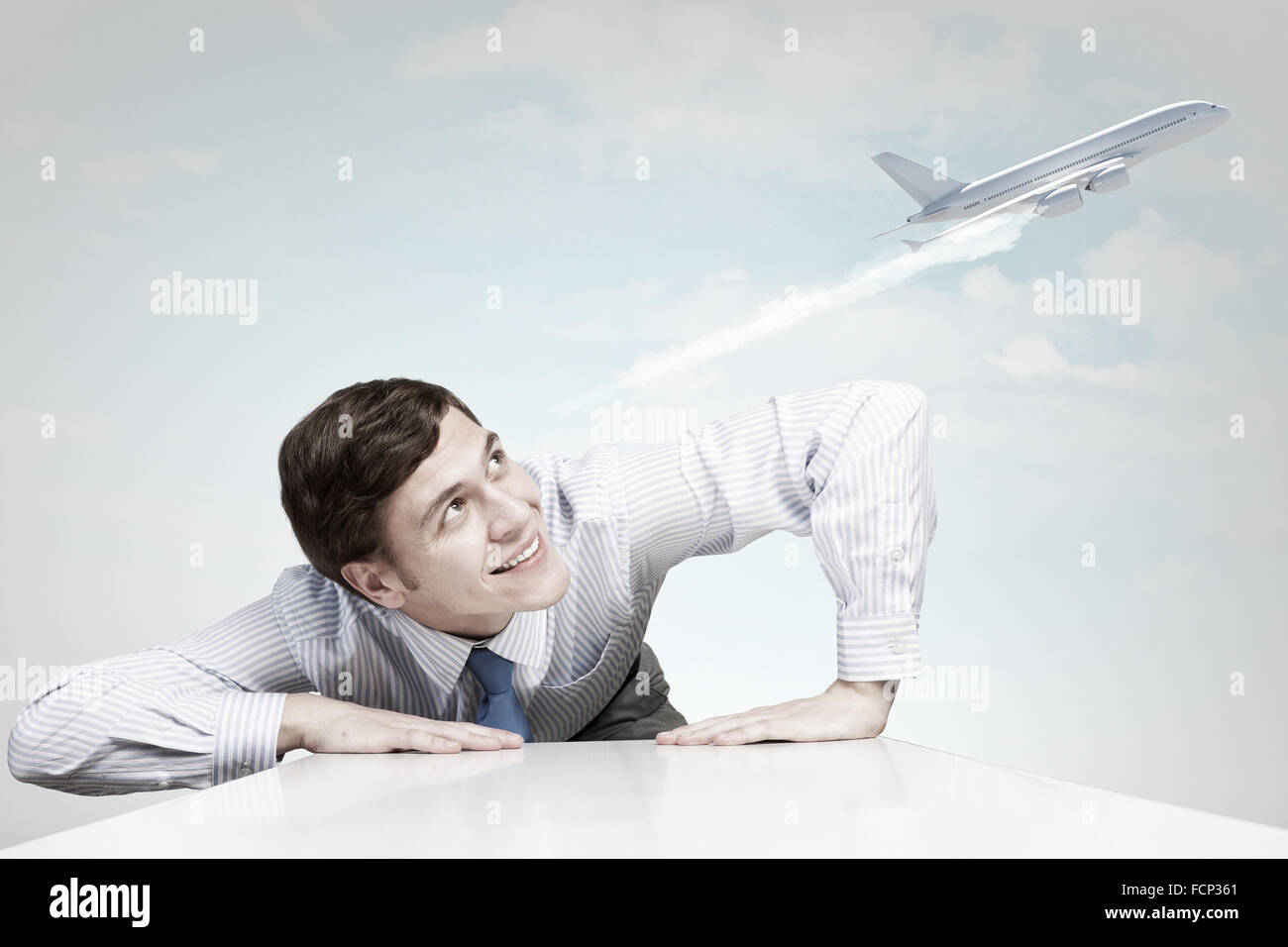 Young man looking from under table on flying airplane Stock Photo - Alamy