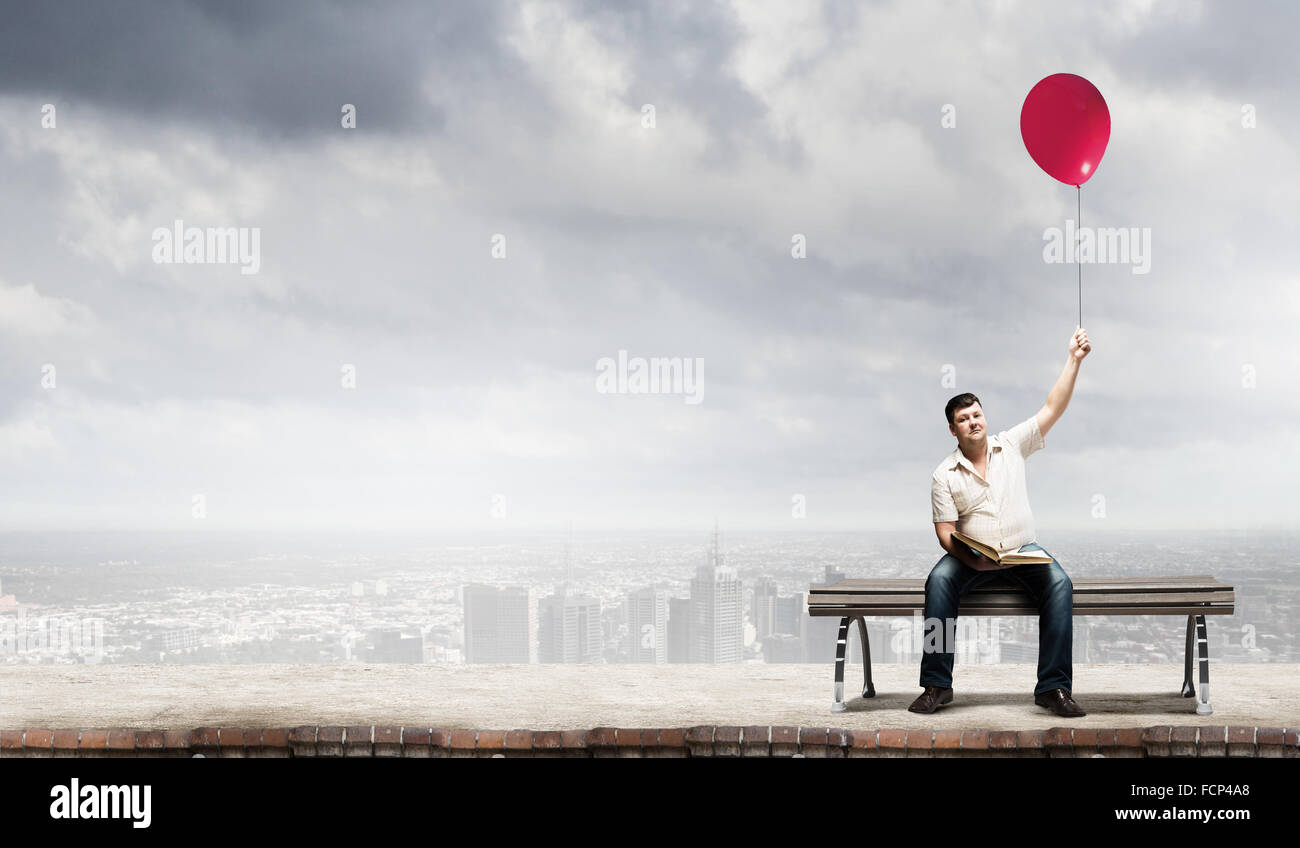 Fat man sitting on bench with book and balloon in hand Stock Photo - Alamy