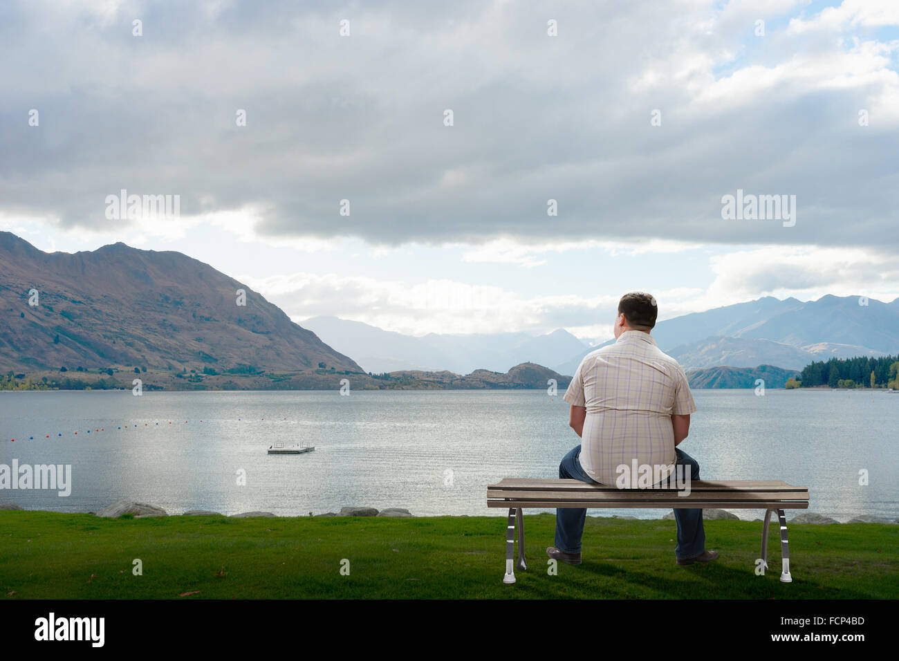 Fat man sitting on bench with his back and looking away Stock Photo - Alamy