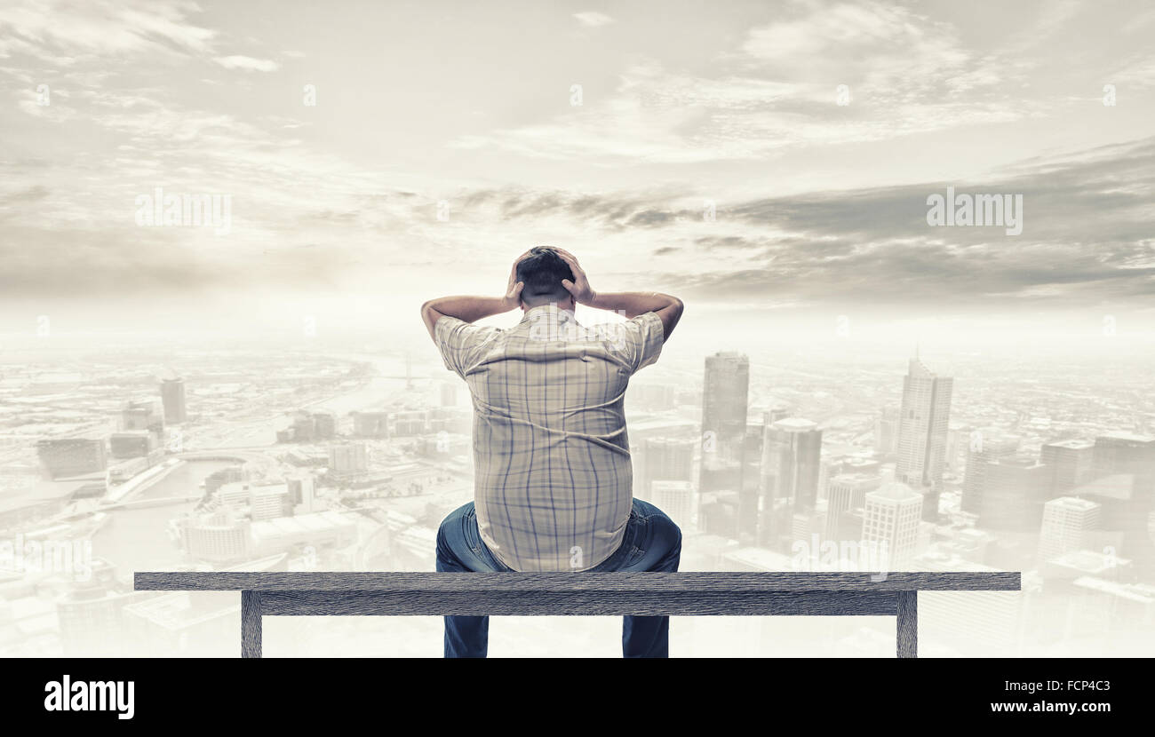 Fat man sitting on bench with his back and looking away Stock Photo - Alamy