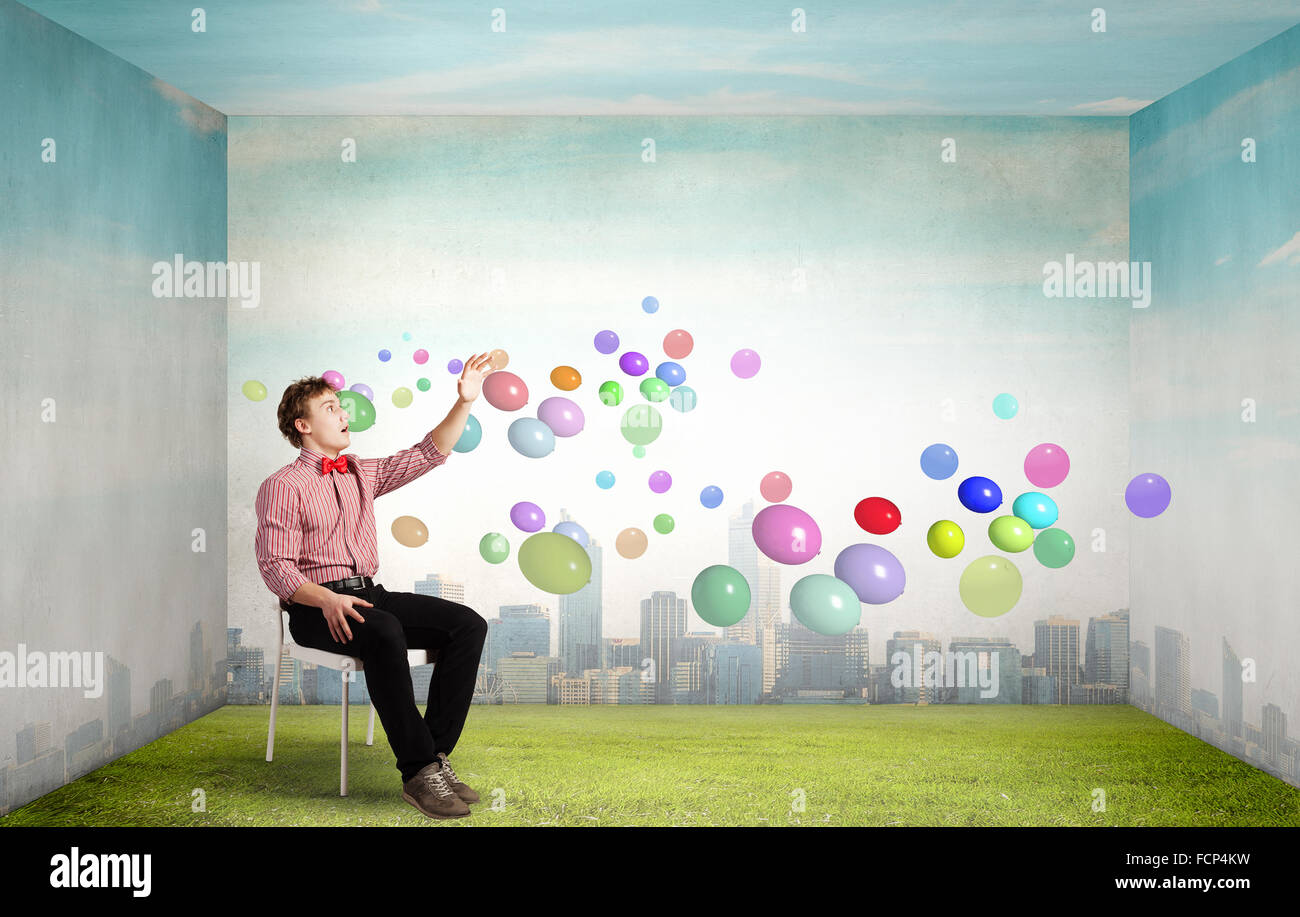 Young funny teenager guy sitting in chair Stock Photo - Alamy