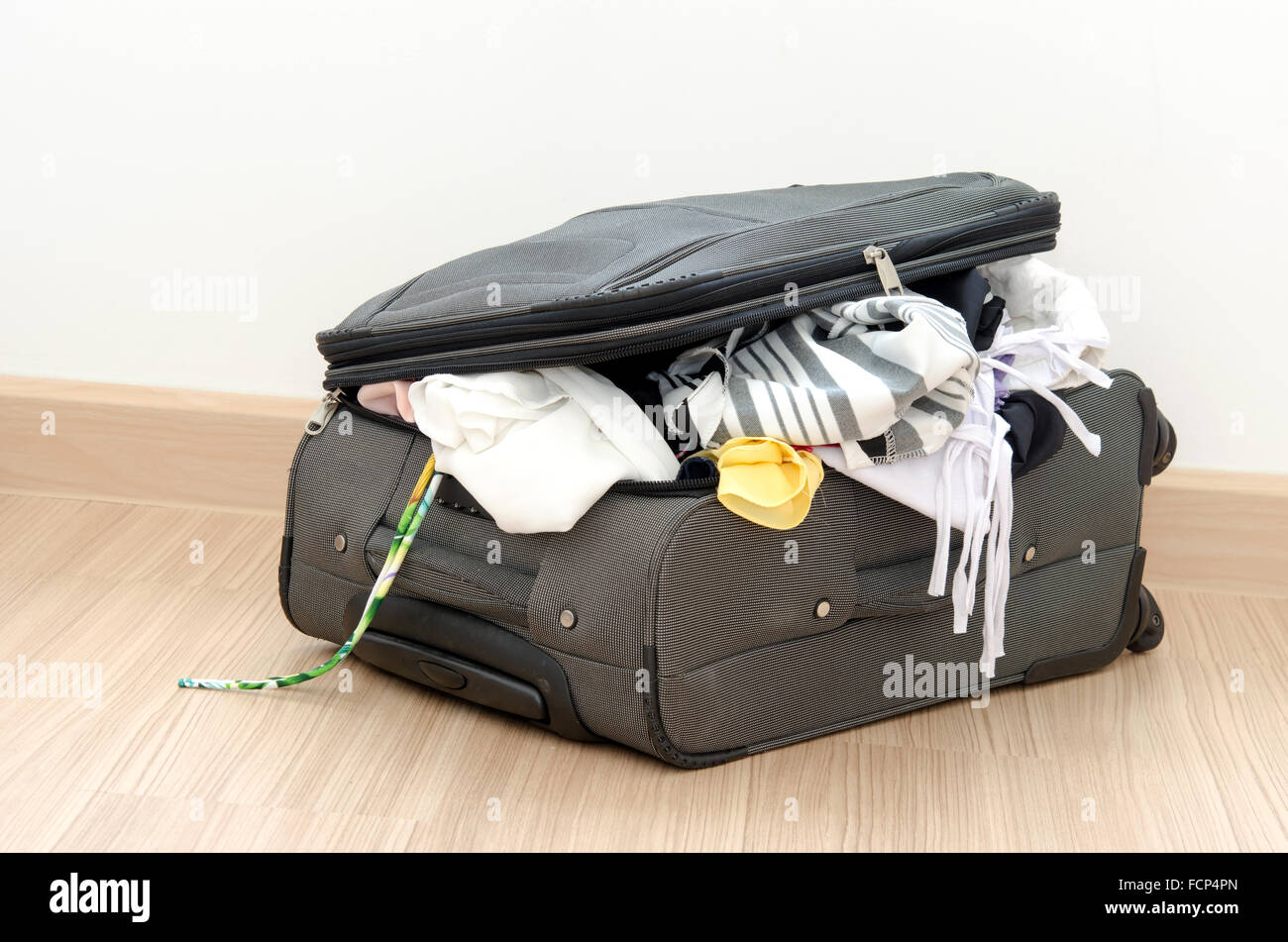 Open suitcase on floor in room Stock Photo - Alamy