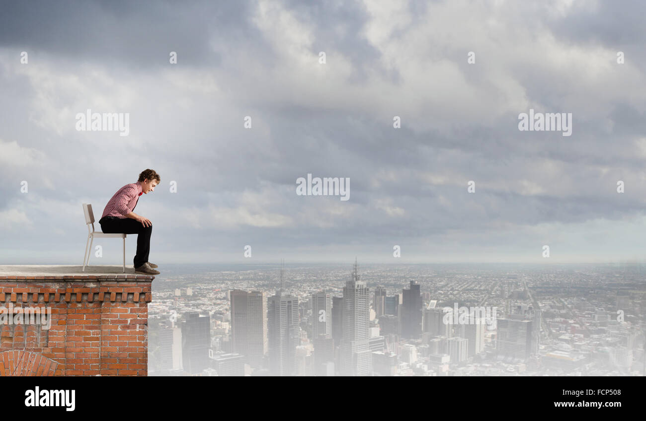 Depressed man sitting on a chair all alone Stock Photo - Alamy