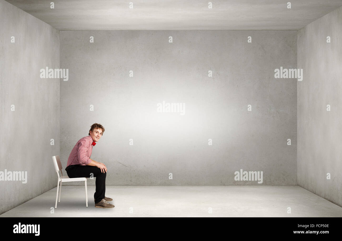 Young funny teenager guy sitting in chair Stock Photo - Alamy