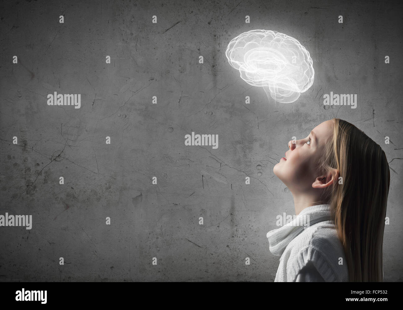 Side view of girl of school age looking at brain above Stock Photo - Alamy